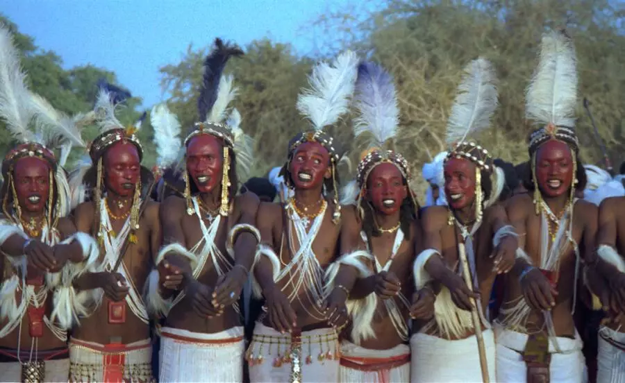Kilpailijat etnisestä ryhmästä Waterab laulaa ja tanssia, paljastavat silmät ja hampaat. Niger. 1997