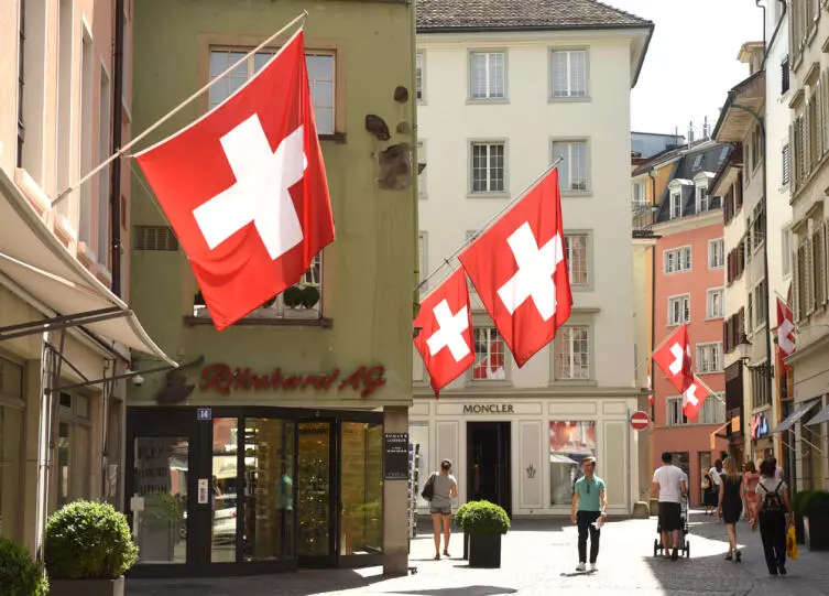 Zurich, Switzerland - Hunyo 03, 2017: Ang mga tao sa Street Czyweier flags sa harapan ng gusali sa makasaysayang sentro ng Zurich, Switzerland